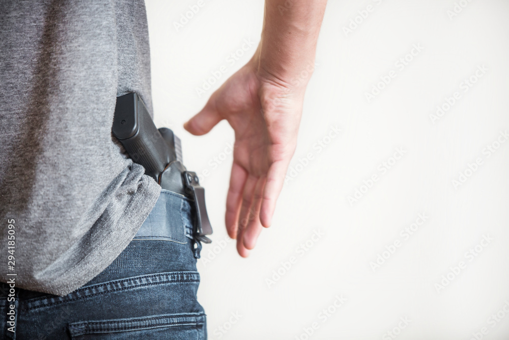 Man holding a gun in his hand with white background, rear view. Stock ...