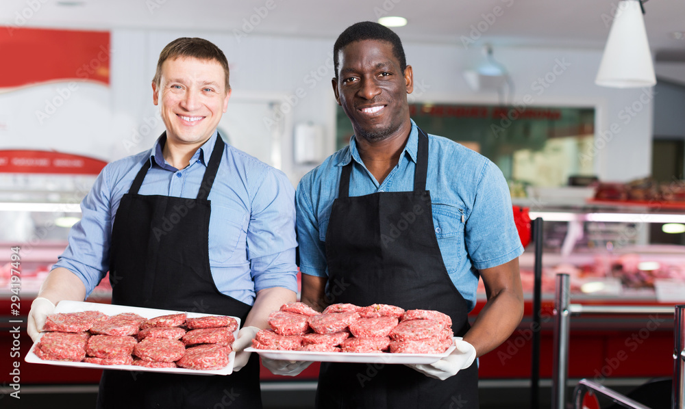 professional butchers standing in butcher shop with trays Stock Photo ...