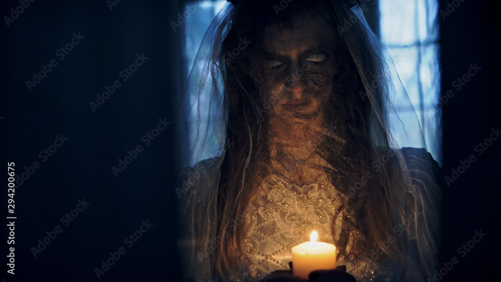Dead bride with a candle in hand in an abandoned house at night. Stock ...