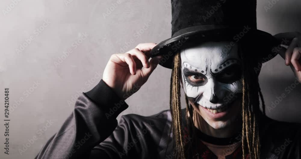 Guy with scary makeup in black hat and dreads hairs. Portrait of man in ...