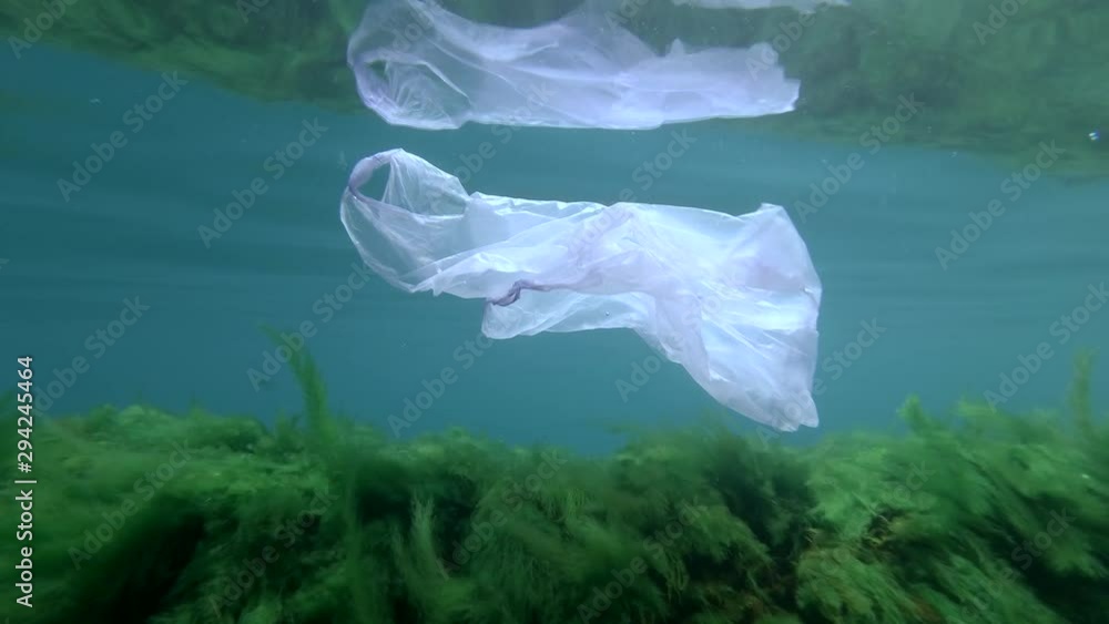 Slow-motion, Plastic pollution, blue plastic bag drifting in shallow ...