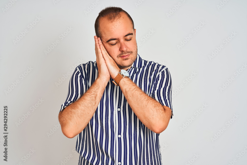 Young man wearing blue striped shirt standing over isolated white ...