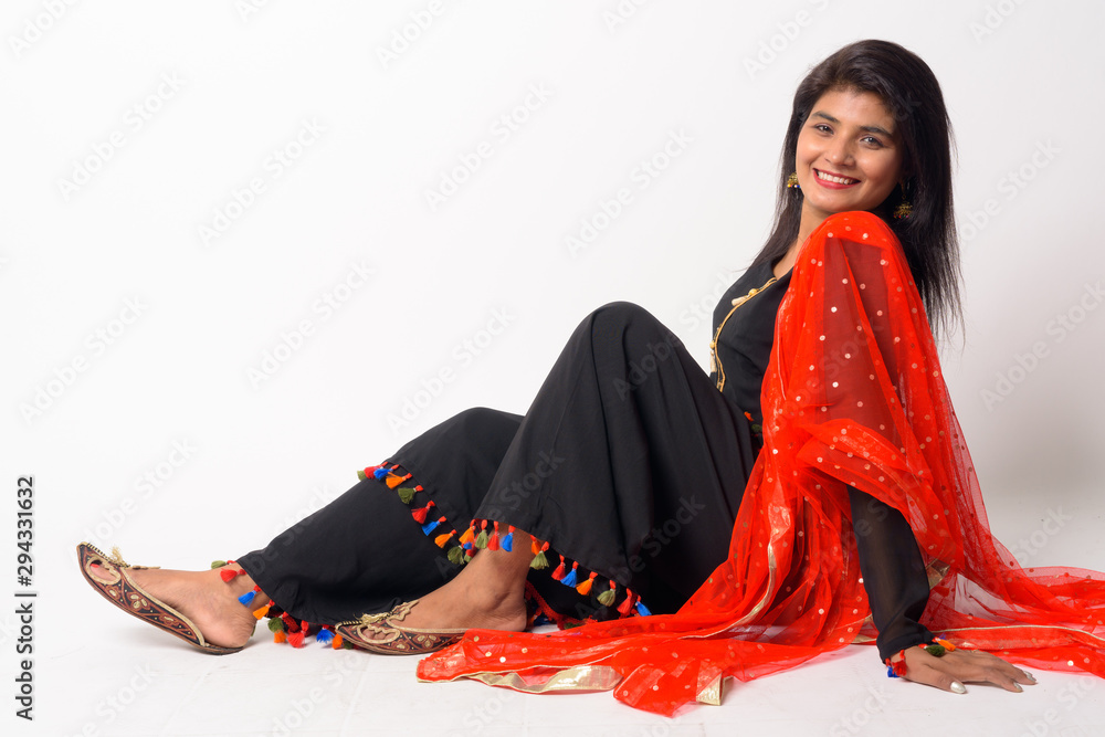 Full body shot of happy young Persian woman sitting on the floor in ...