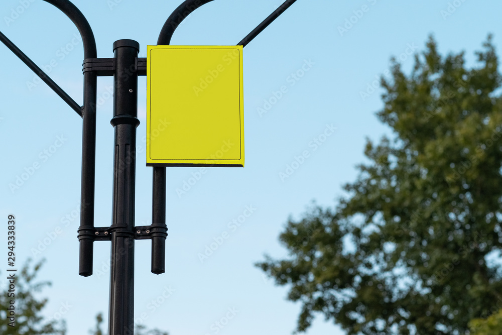 empty yellow signboard on a metal pole against the blue sky with a copy ...