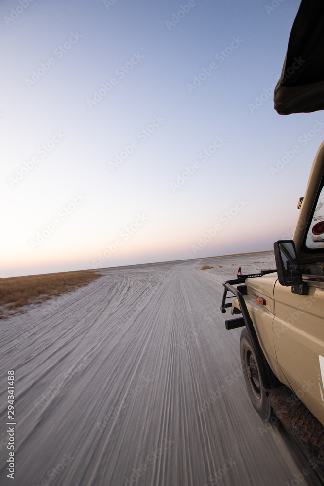 4x4 off-road vehicle during the sunset runs fast on a dirt track in ...