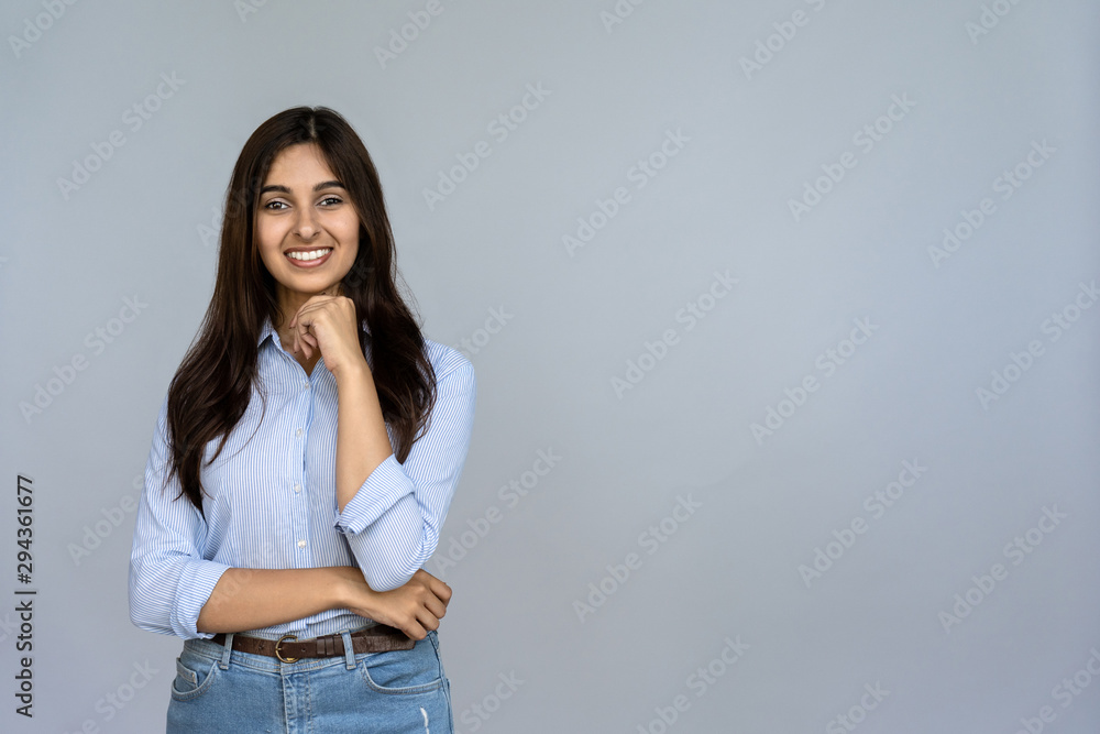 Smiling young indian woman girl teacher stand isolated on grey ...