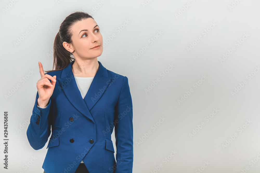Serious young teacher standing, raising her finger up, calling to pay ...