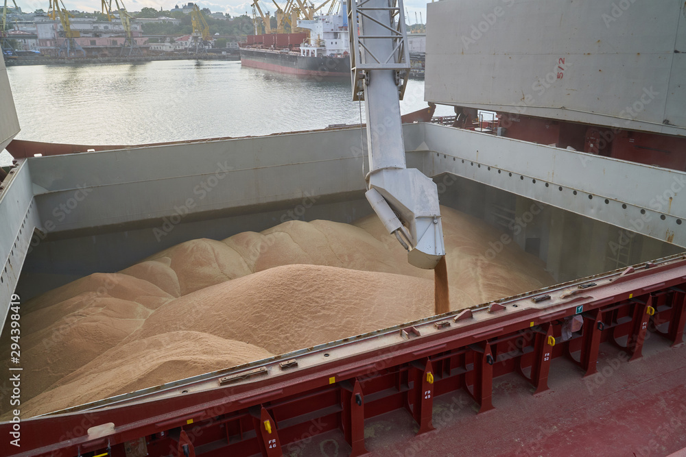 Fotka „Grain loading in hold of bulk carrier ship with elevator crane ...