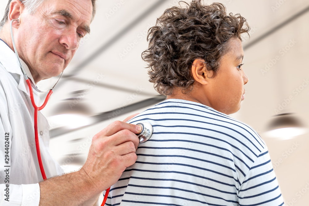 Close up of teen boy and doctor with stethoscope listening to heartbeat ...