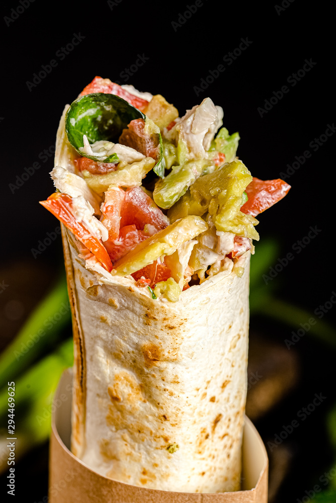 Freshroll shawarma with chicken meat, avocado, standing and lying in a ...