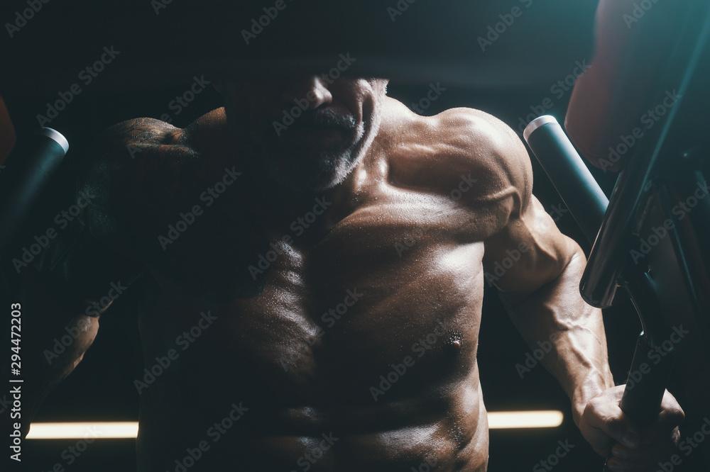 Handsome athletic men pumping up muscles push-ups on uneven bars ...