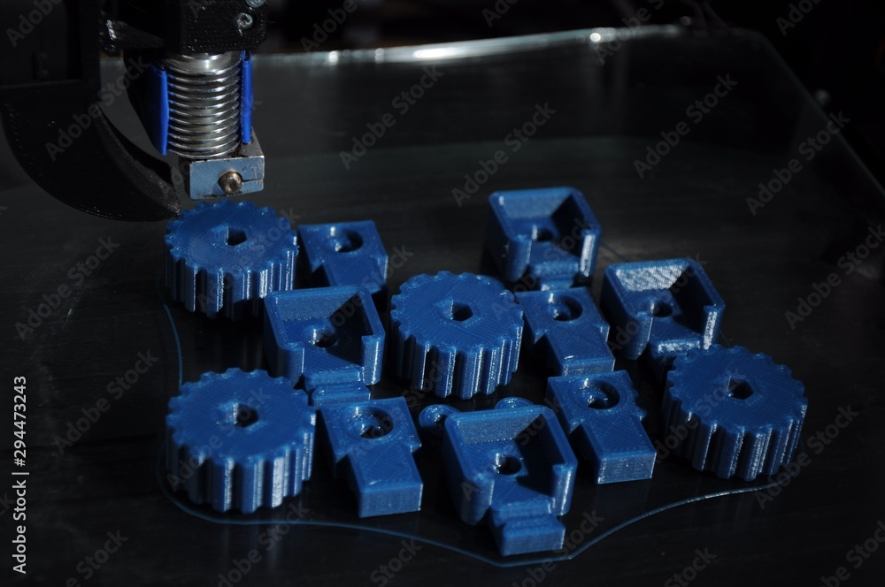 3D printed parts made of blue plastic and the print head of the printer ...