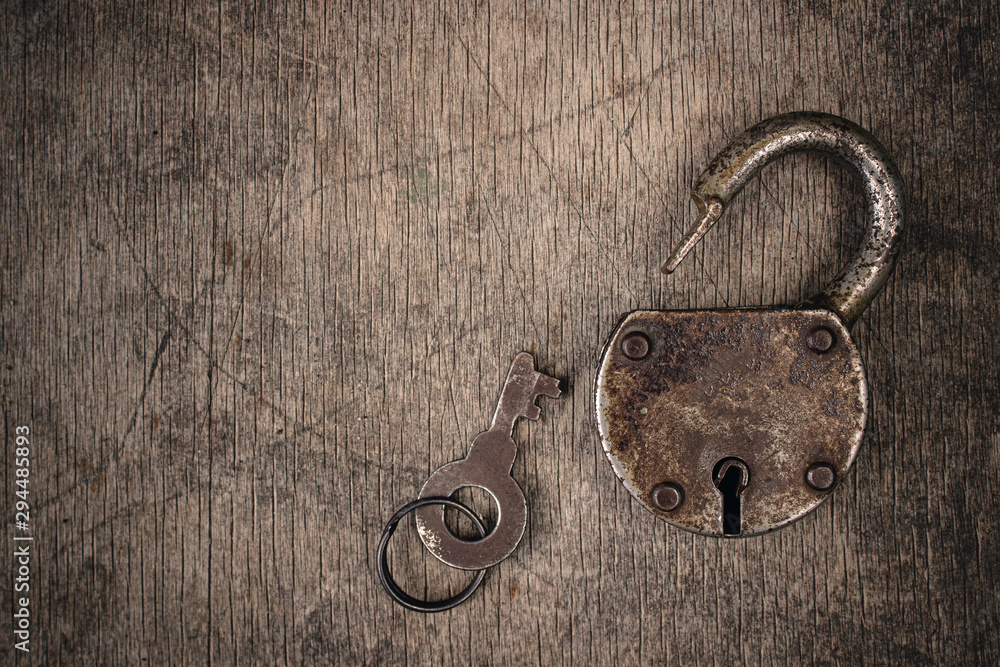 Old vintage lock with key. Ancient rusty barn lock with key on wooden ...