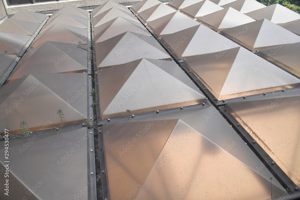 Pyramid of tiles roof. White metallic pyramid of tiles roof, background ...