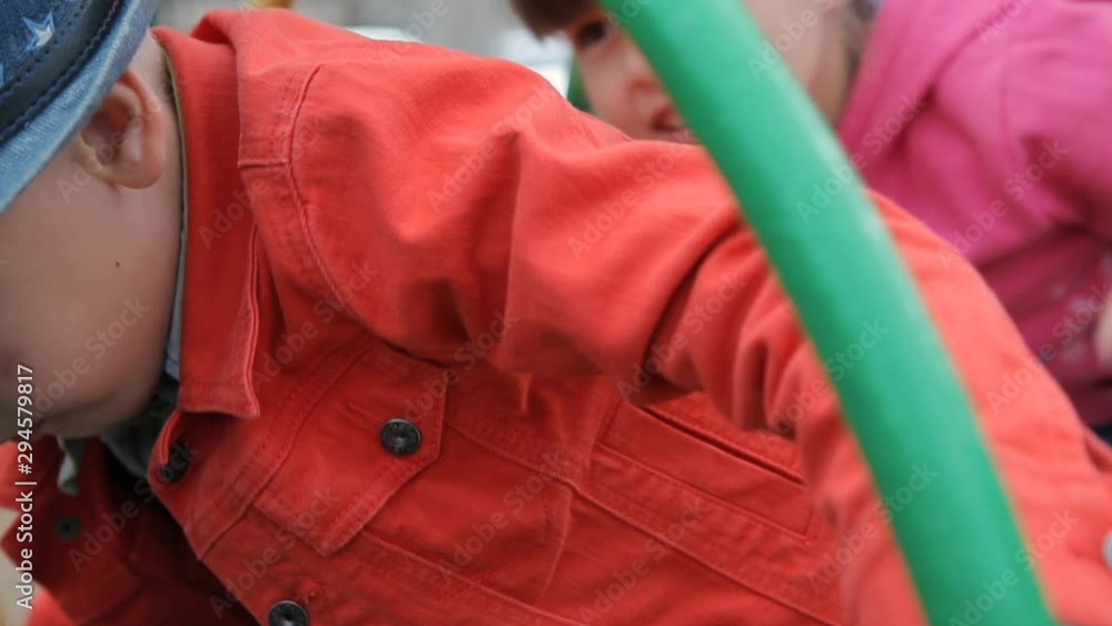 Happy children play in the playground. A boy and a girl climb elements ...
