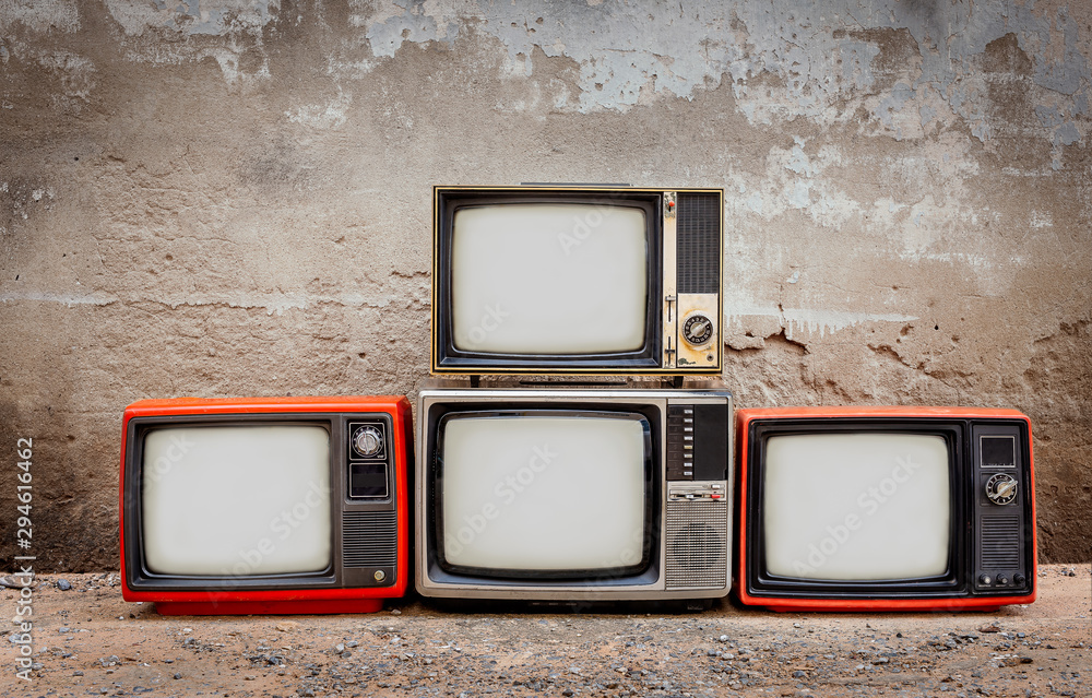 Four retro old television pile on the floor. Four old TVs placed in ...