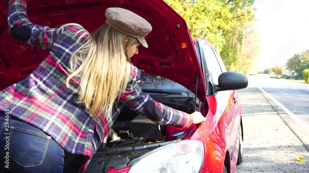 A woman closes the car boot on the side of the road after repair Stock ...