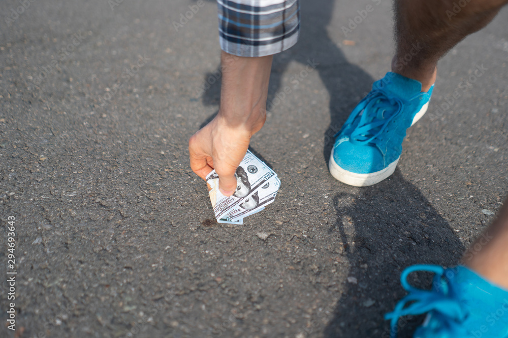 person find paper money lost and dropped on the asphalt ground outdoor ...