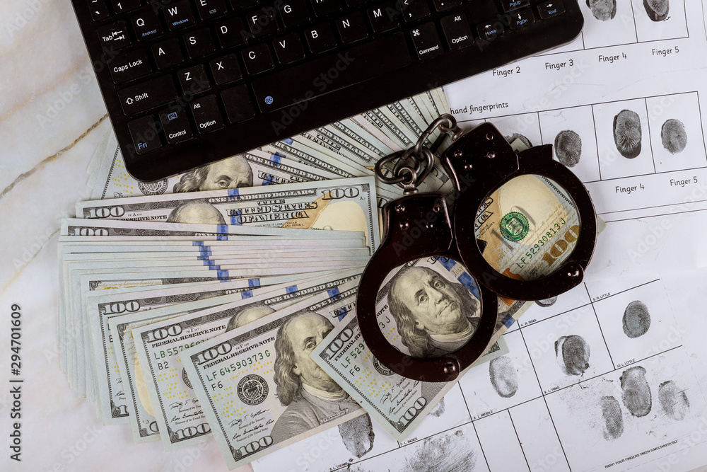 Cyber crime legal law police handcuffs on a hundred dollar bills with ...