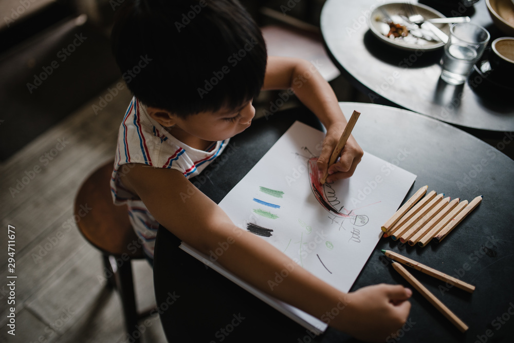 Boy drawing with color pencils Stock Photo | Adobe Stock
