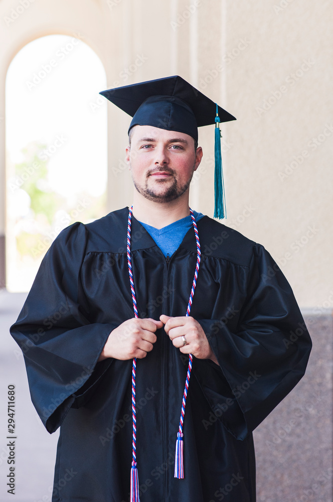 Smiling portrait of male graduate in black cap and gown Stock Photo ...