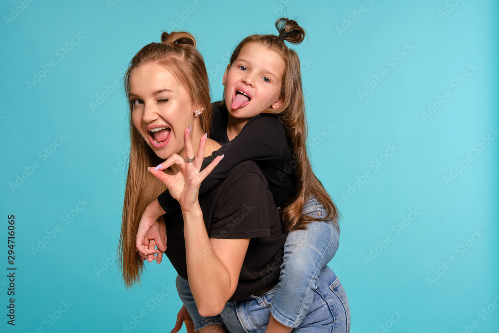 Mom and daughter with a funny hairstyles, dressed in black shirts and ...
