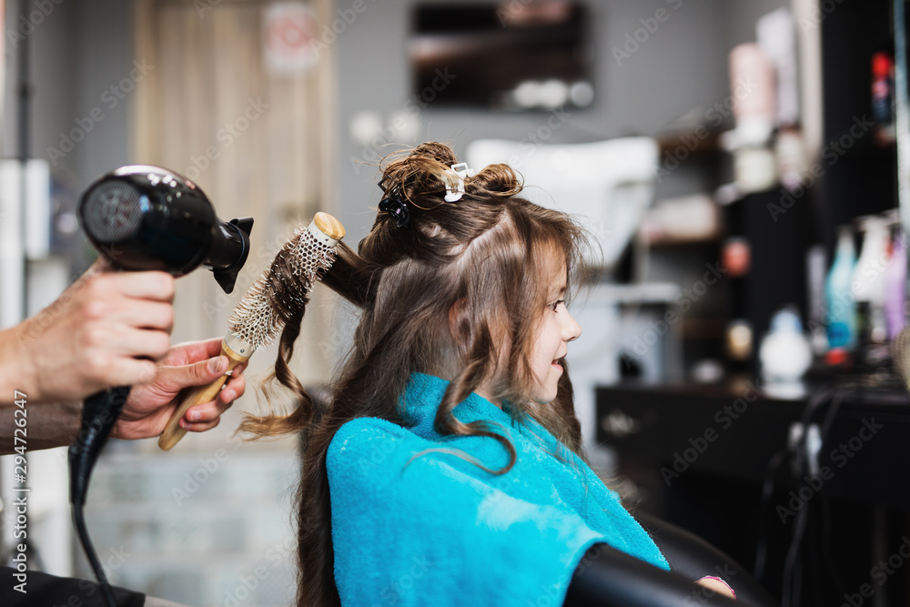 Beautiful hairstyle of cute girl in hair salon. Stock Photo | Adobe Stock