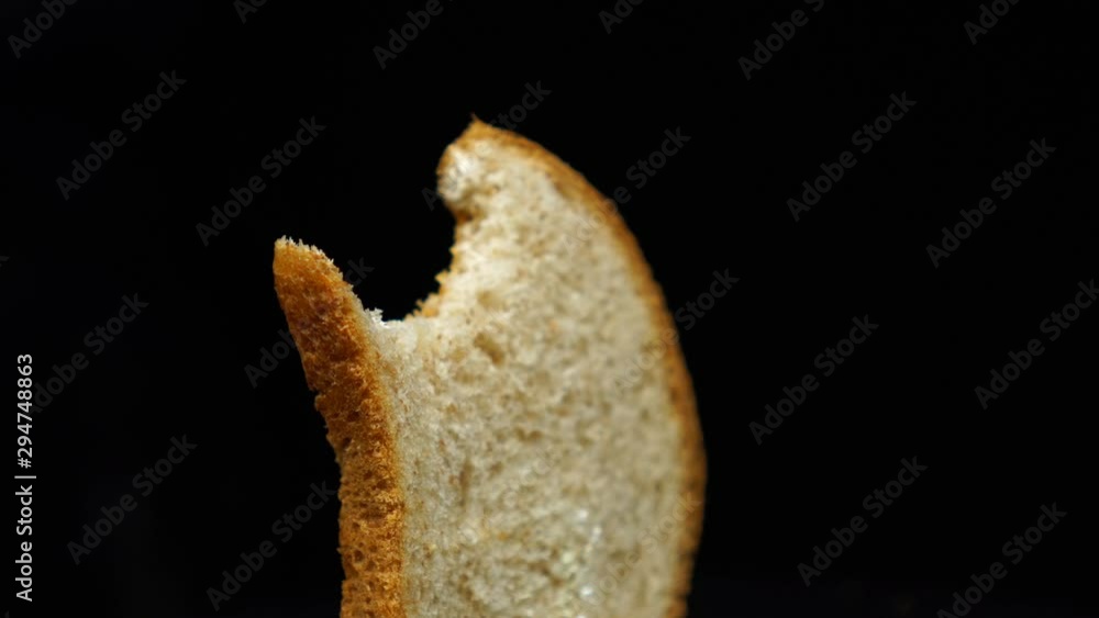 Vidéo Stock Bitten slice of the toast bread rotates, isolated over the ...
