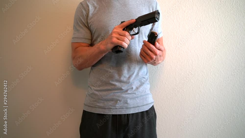 Angry man loading a magazine full of bullets into a semi automatic ...
