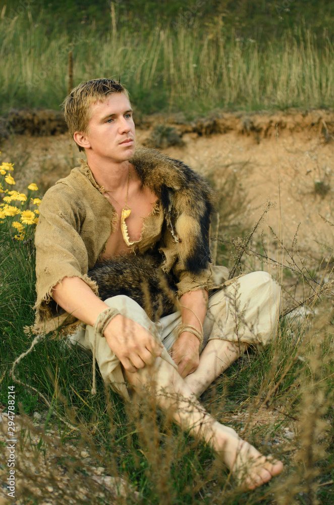 portrait of a young medieval peasant or hunter in a suit of old burlap ...