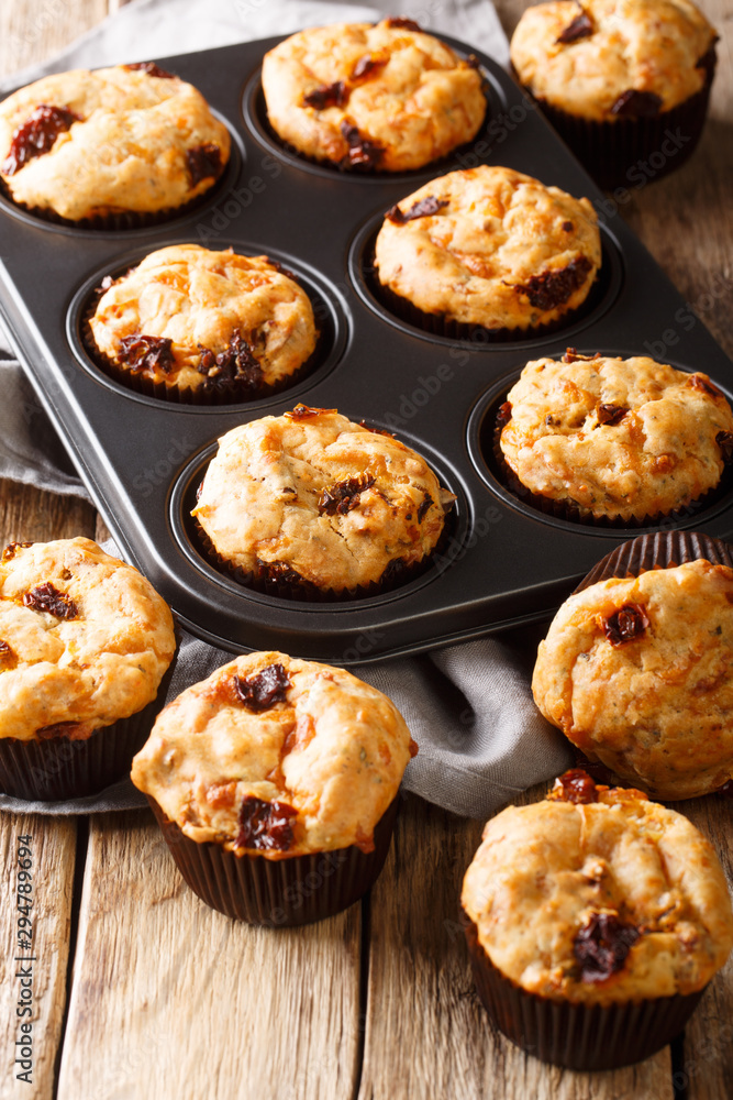 Snack savory muffins with sun-dried tomatoes and cheddar cheese close ...