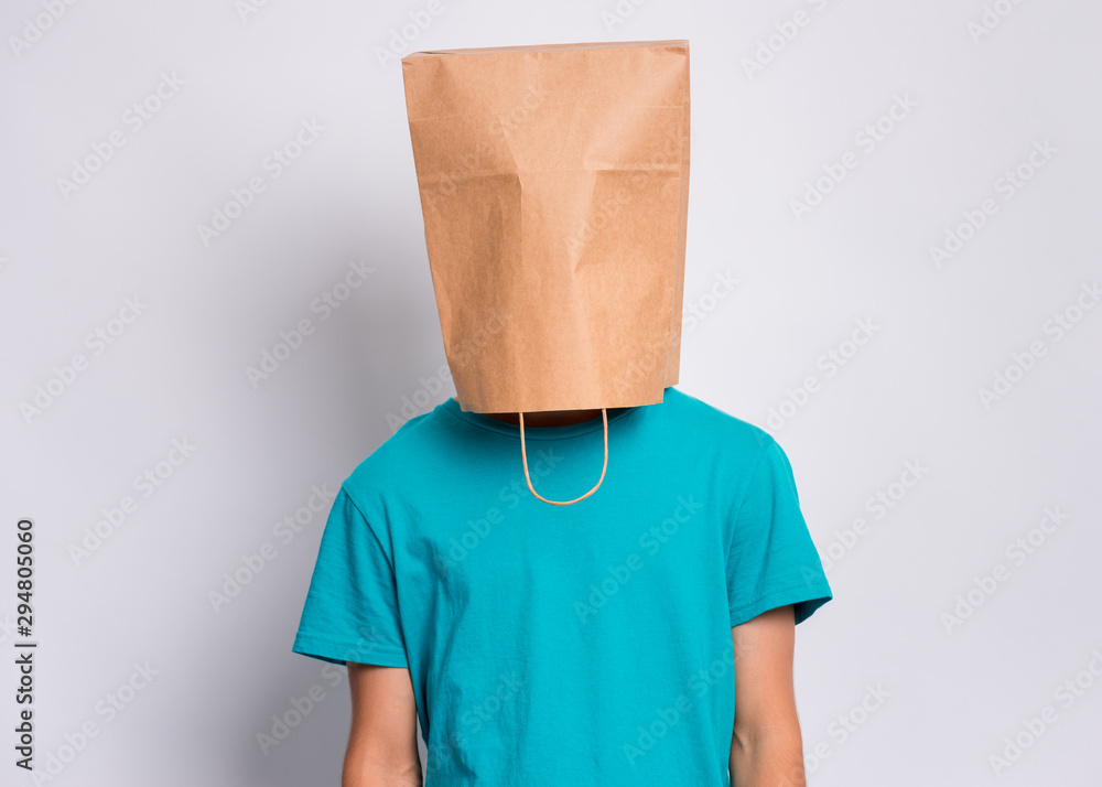 Portrait of teen boy with paper bag over head. Teenager cover head with ...