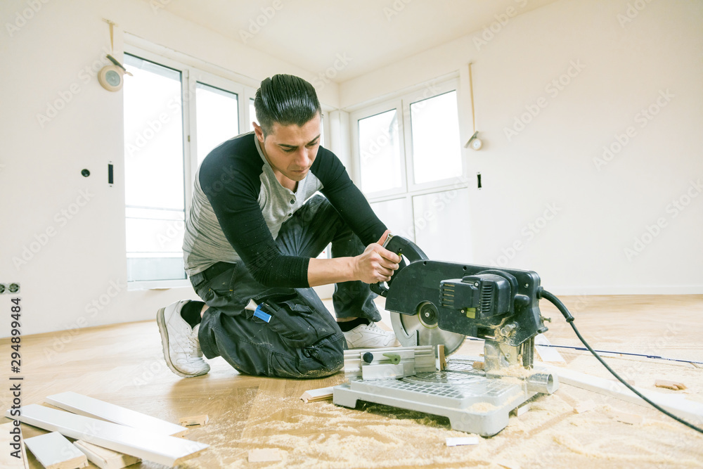 Bodenleger arbeitet in einem neubau haus an einem parkett boden. Stock ...