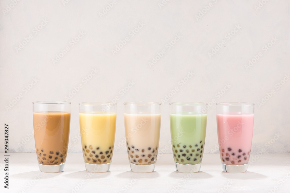 Row of fresh boba bubble tea glasses on white background. Stock Photo ...