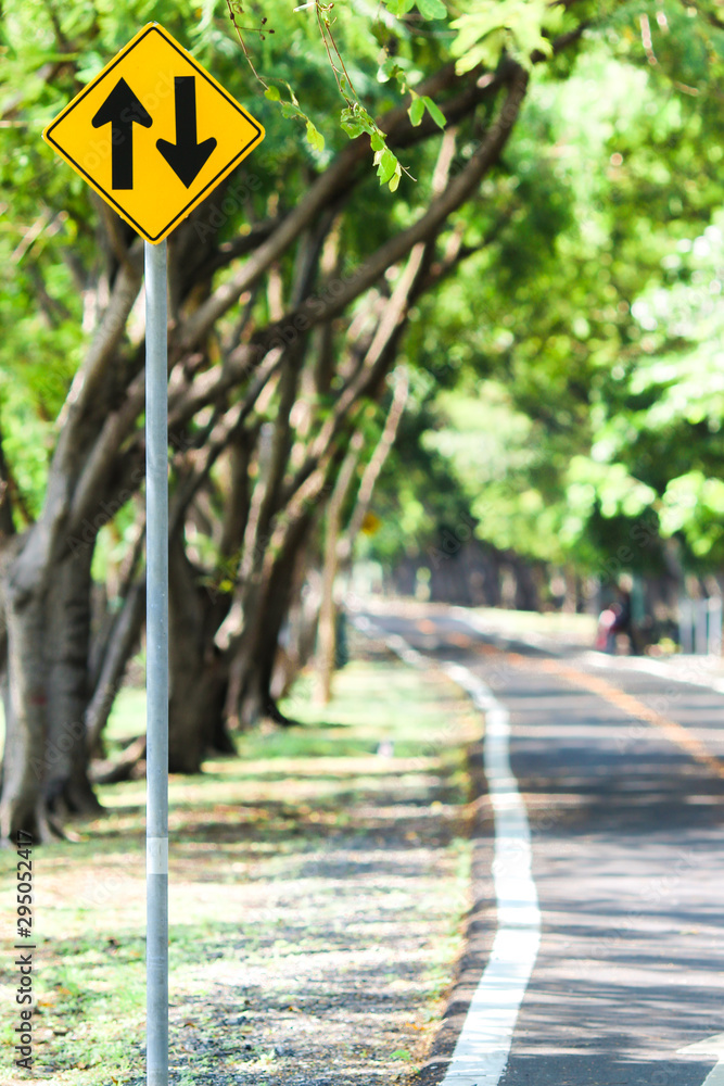 Yellow traffic signs in the park indicate that this road is a 2-lane ...