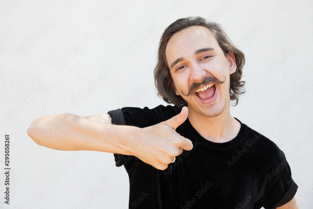 Excited cheerful guy making like gesture. Handsome young man with curly ...