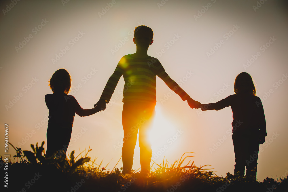 silhouettes of kids - boy and girls - holding hands at sunset Stock ...