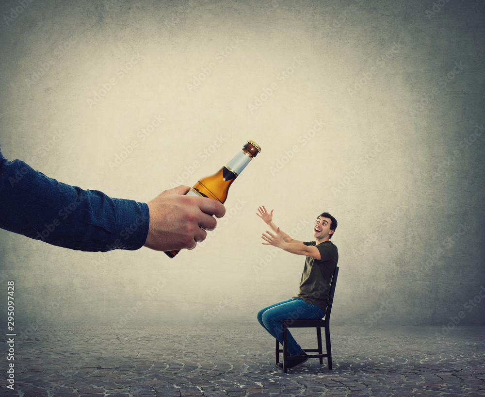 Alcohol addicted man, hands outstretched, receiving a huge bottle of ...