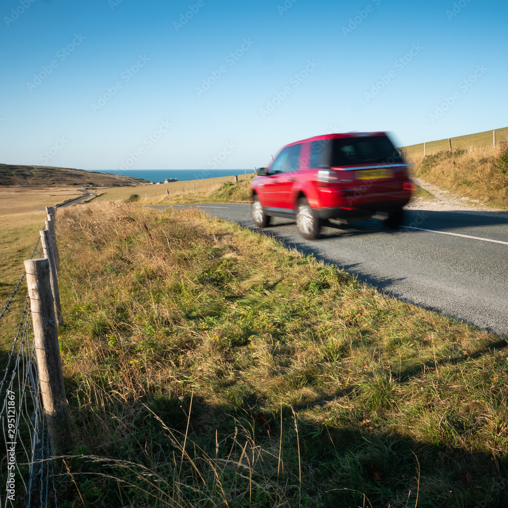 English Road Trip. A car travelling a winding road on the South Downs ...