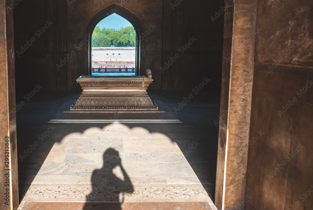 Shadow of a tourist photographer and a white marble cenotaph inside a ...