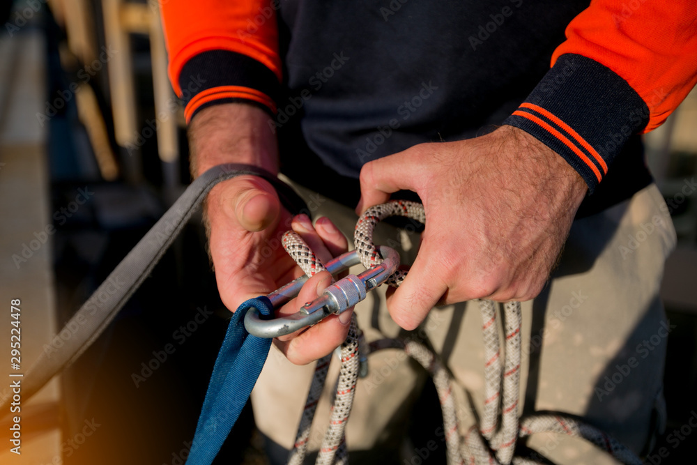 Rope access worker inspecting closing rigging on locking Karabiner its ...