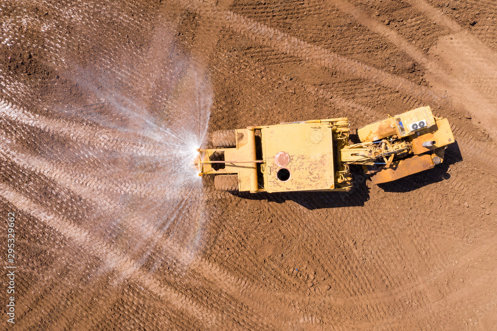 Articulated Water Truck spraying water on a large Excavation site ...