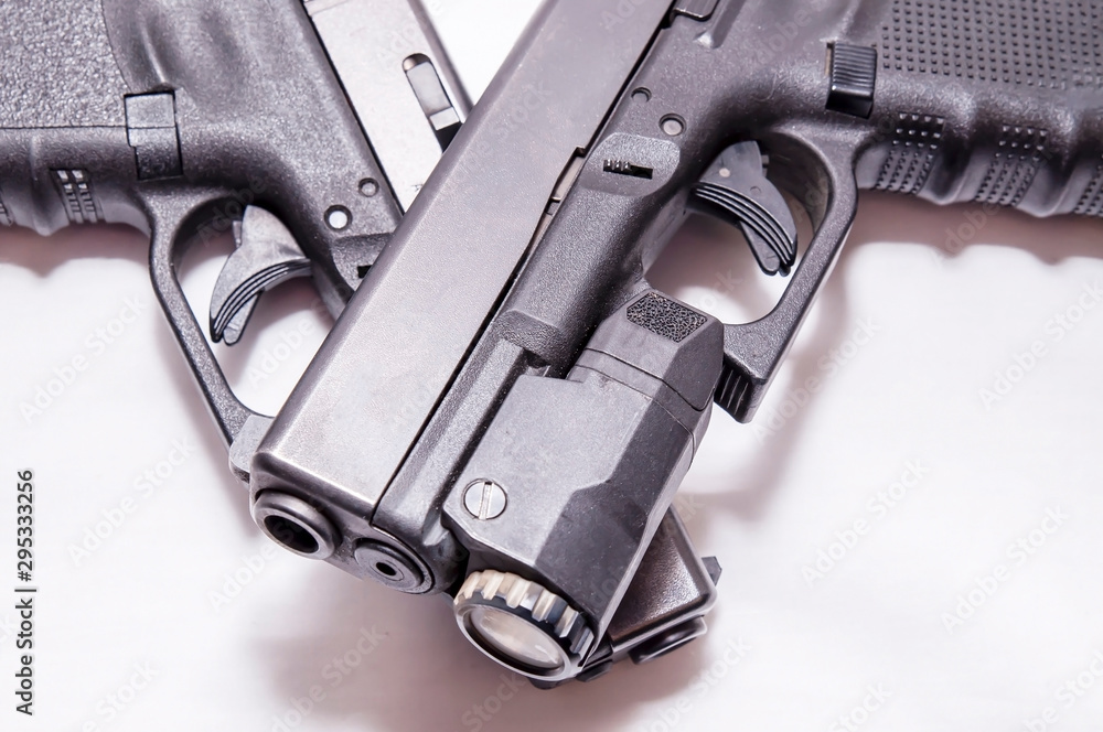 Two black semi automatic 9mm pistols, one with a flashlight attached ...