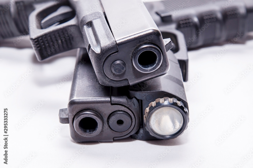 Two black semi automatic 9mm pistols, one with a flashlight attached ...
