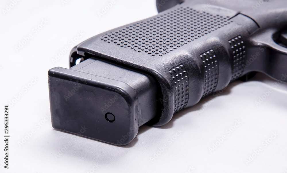 An extended pistol magazine out of the grip of a black semi automatic ...