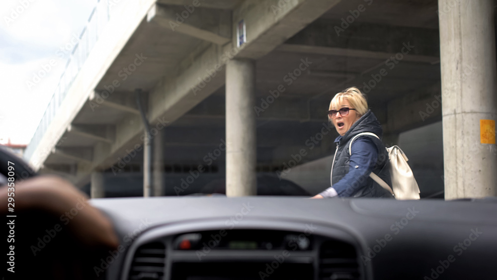 Inexperienced automobilist driving car city, scared woman running away ...