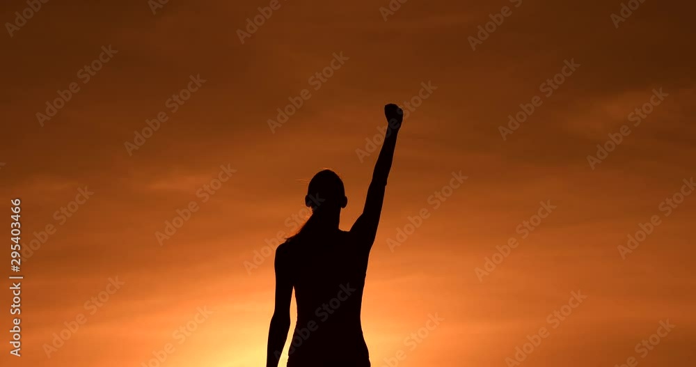 Strong, victorious , and motivated young woman raising her fist up in ...