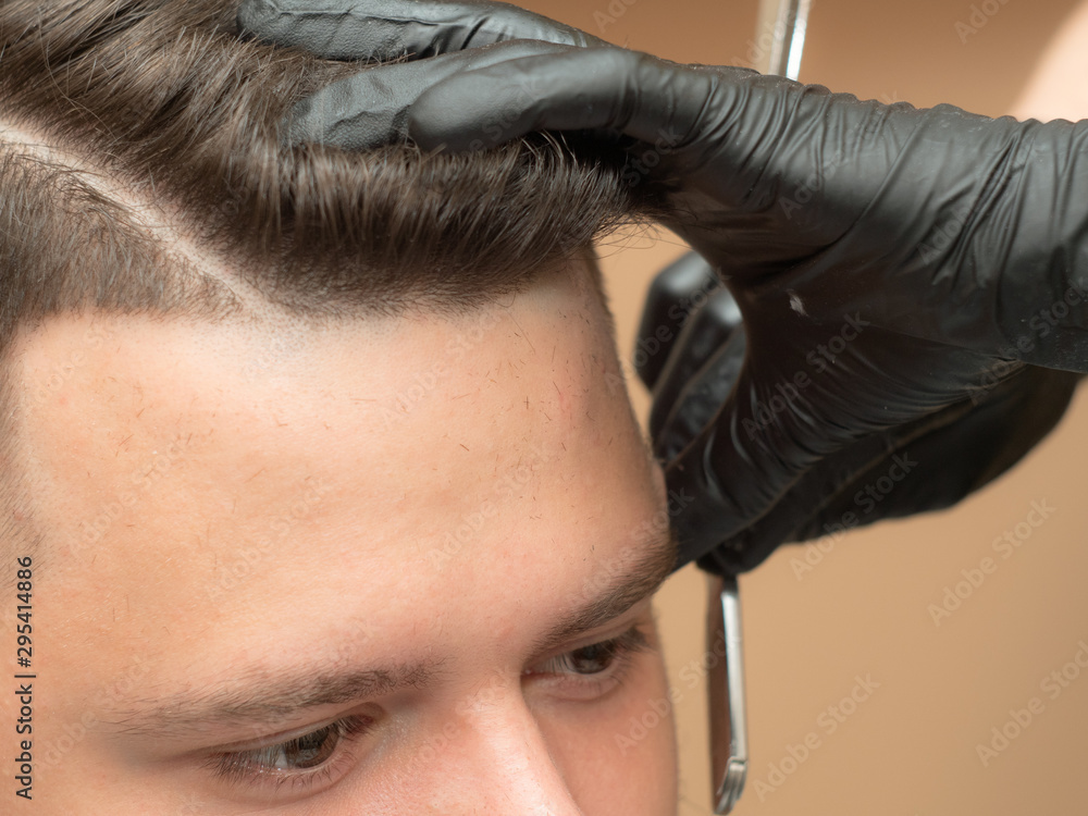 Hairdresser shaving clients temples with open razor, close up view ...