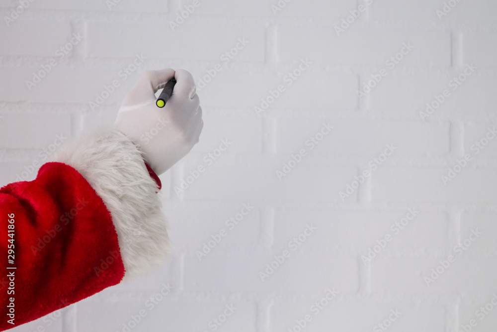 Santa Claus writing with the pen on the white brick wall Stock Photo ...