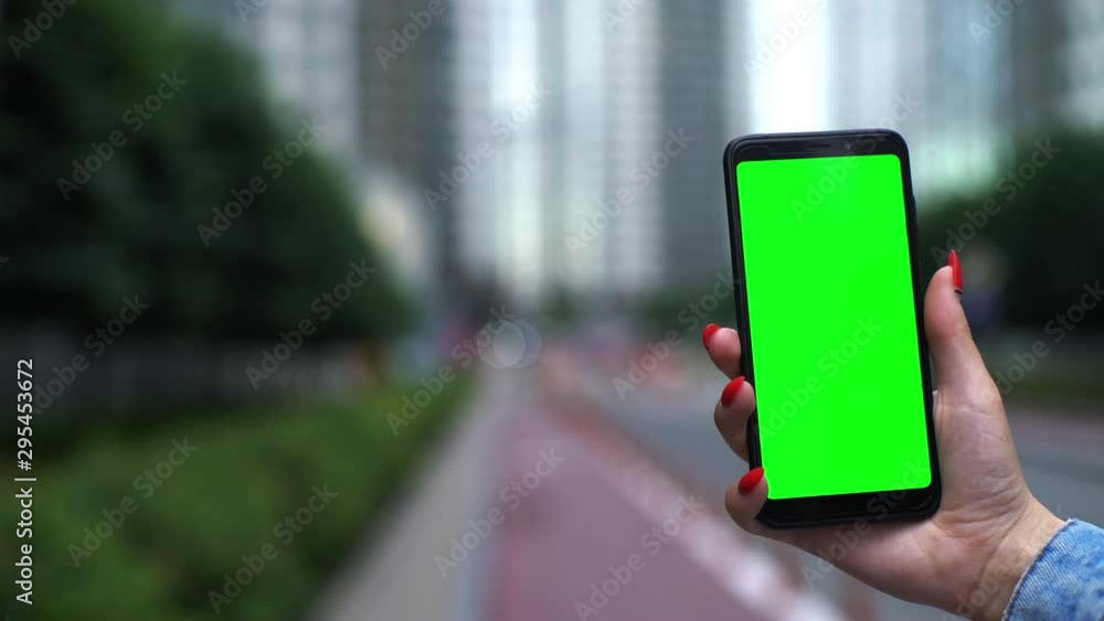 Young girl holding in arms electronics gadget with greenscreen touchpad ...